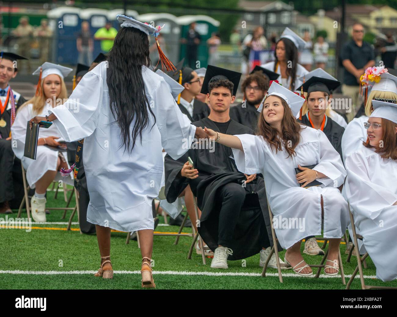 Graduates march into the school stadium to receive their diplomas ...