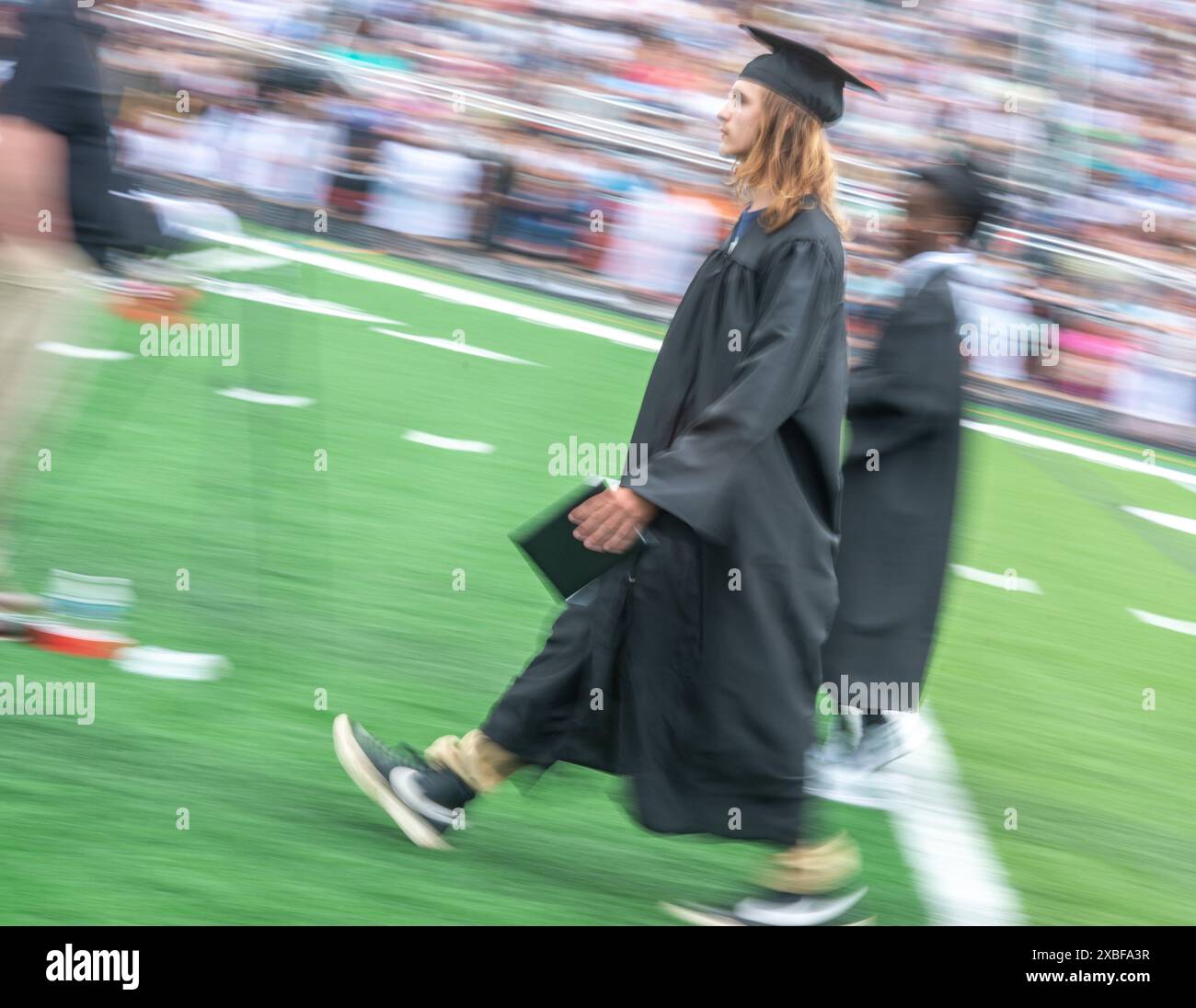 Graduates march into the school stadium to receive their diplomas ...