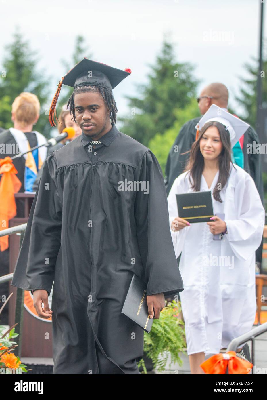 Graduates march into the school stadium to receive their diplomas ...