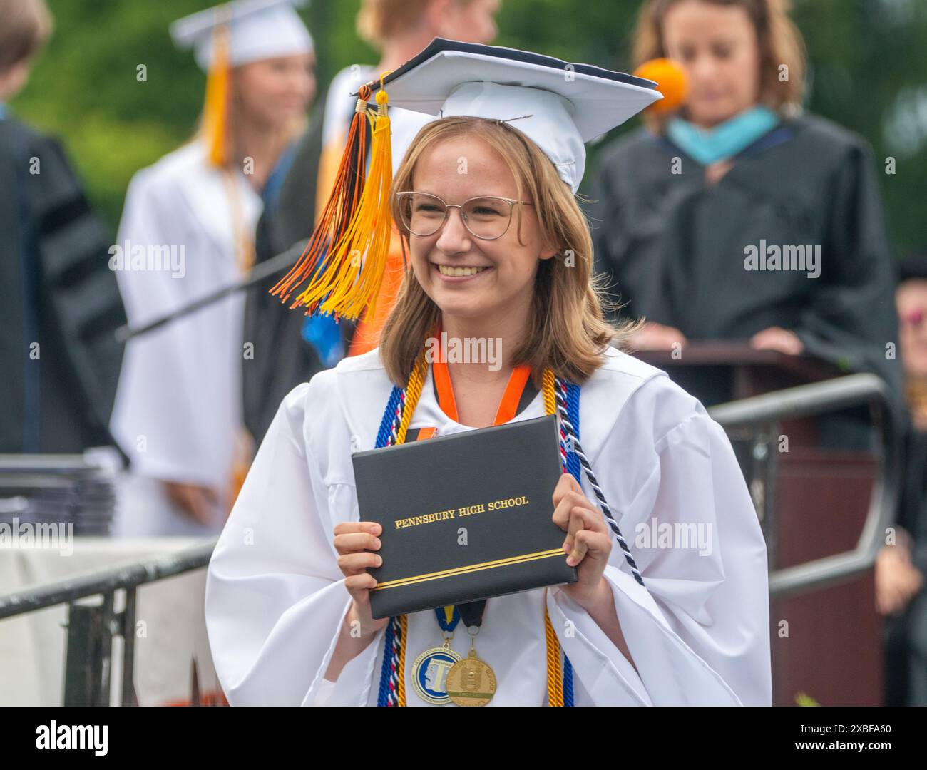 Graduates march into the school stadium to receive their diplomas ...
