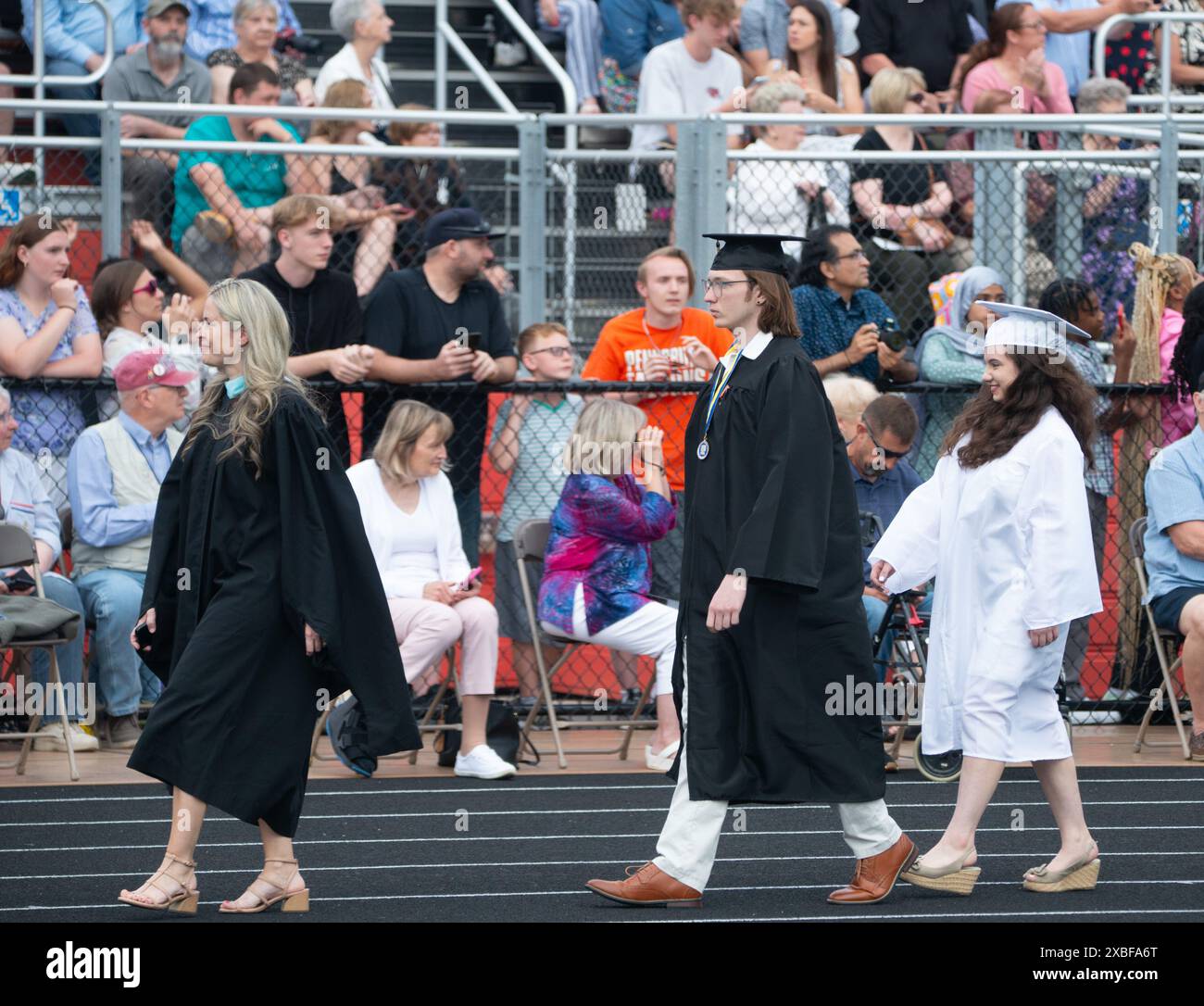 Graduates march into the school stadium to receive their diplomas ...