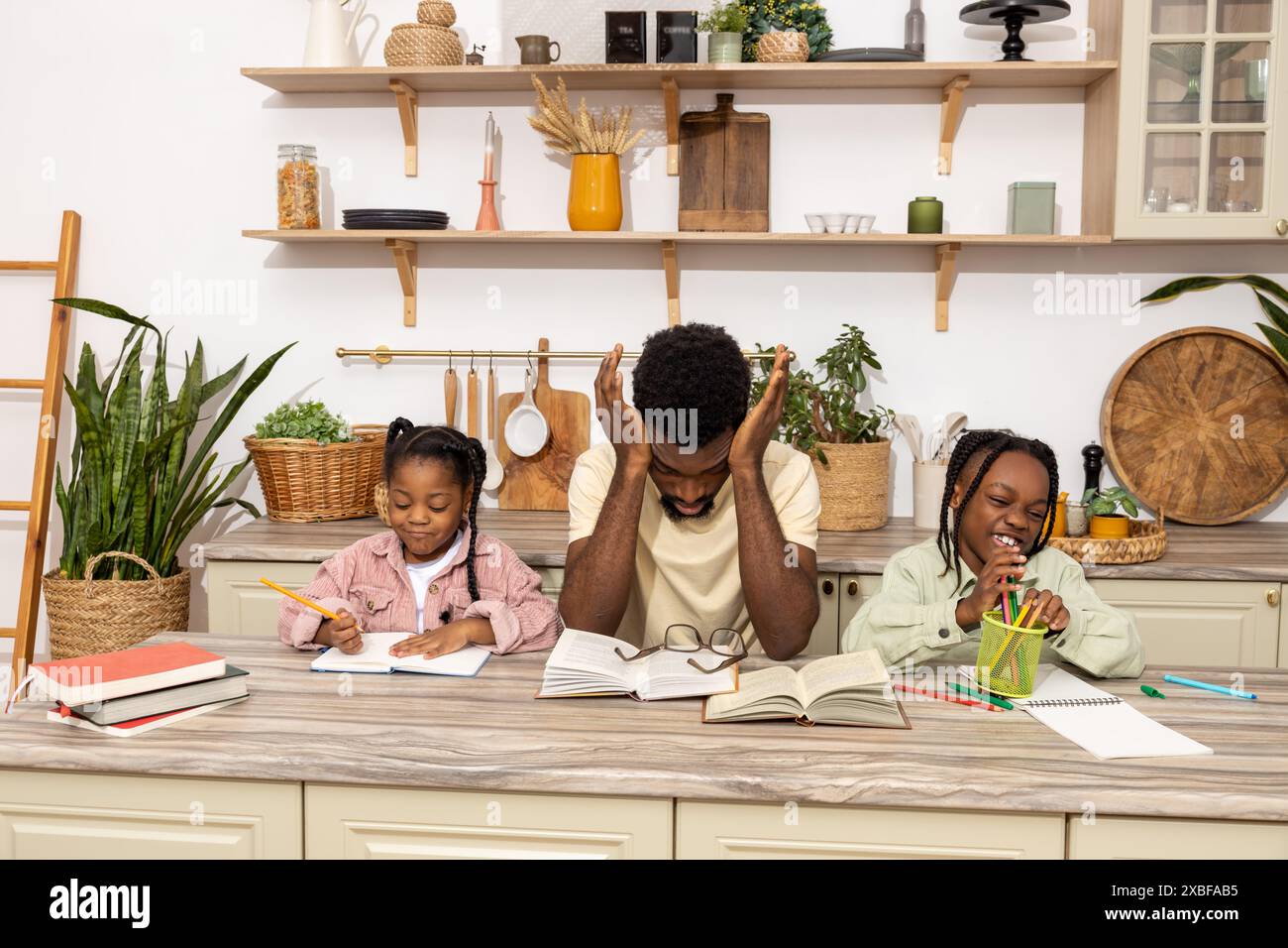 Tired father and children gathering around table doing kid's homework ...