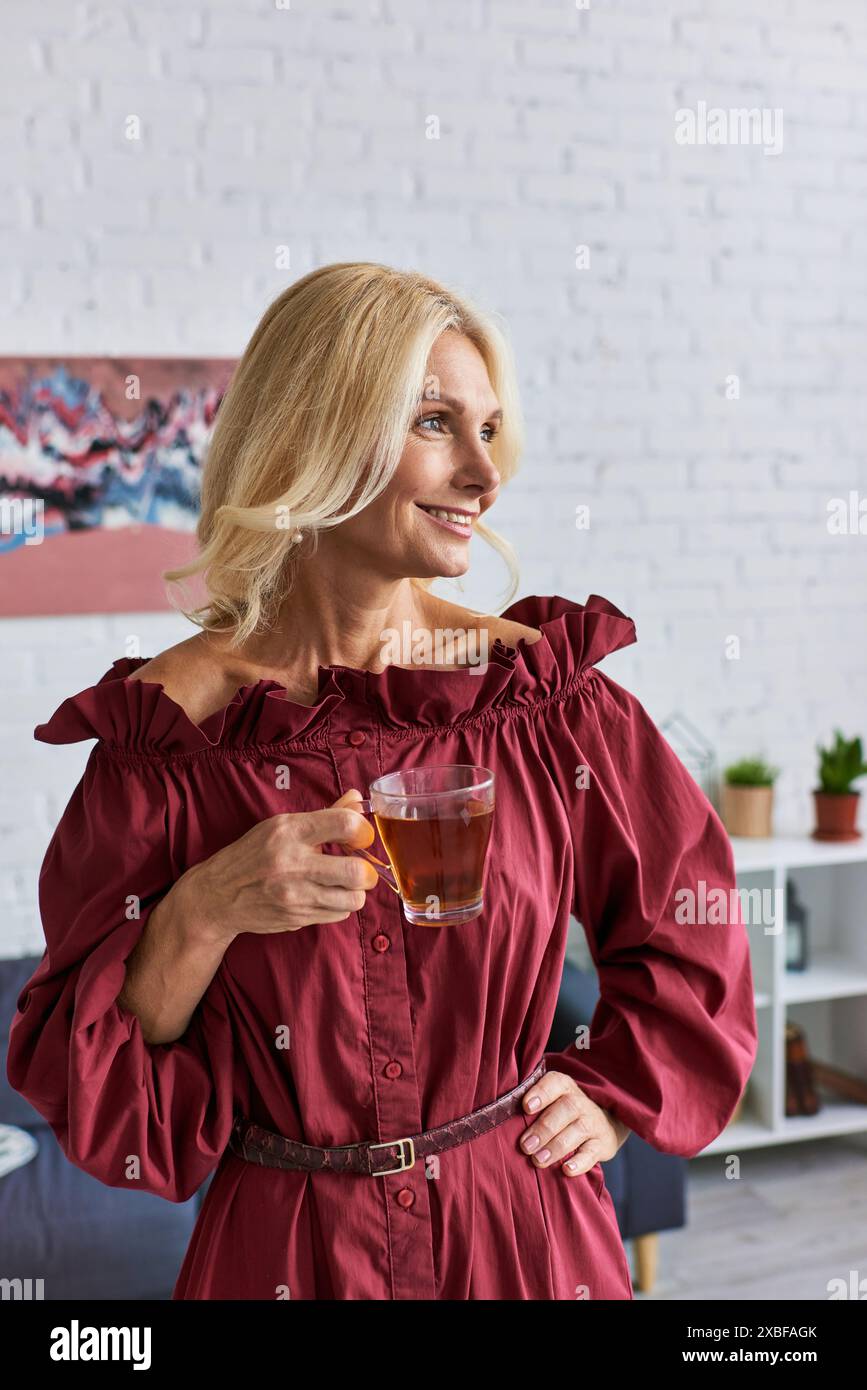 Mature lady in red dress enjoys a drink Stock Photo - Alamy
