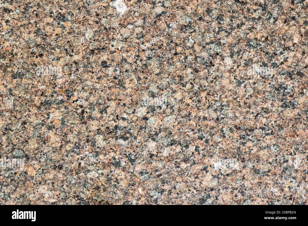 A close up of a granular granite surface with numerous small stones on ...