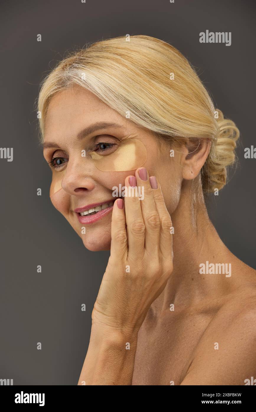 Blonde mature woman with eye patches on a gray backdrop Stock Photo - Alamy