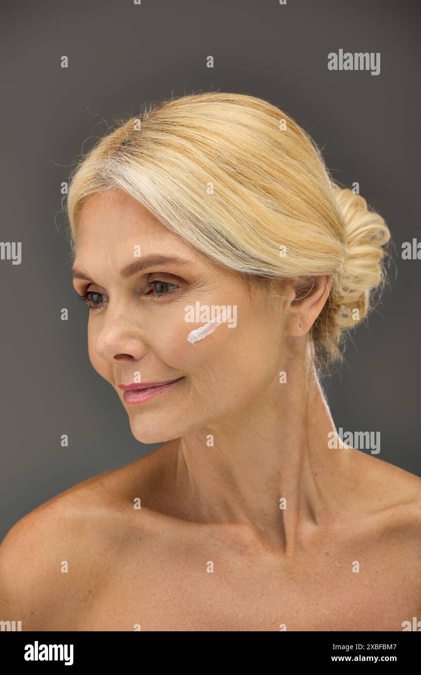 Mature woman showcasing her skincare routine with cream on face Stock ...