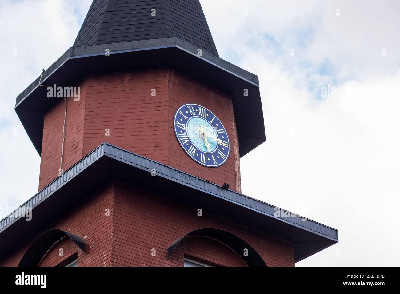 On the peak of a brick building, a clock reads 1010. The keywords for ...