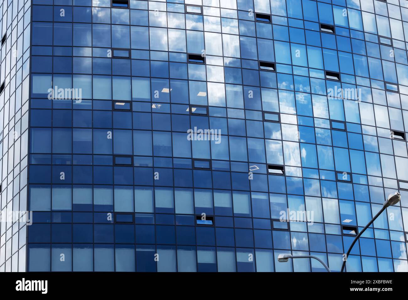 A tall building with numerous windows stands out against a clear blue ...