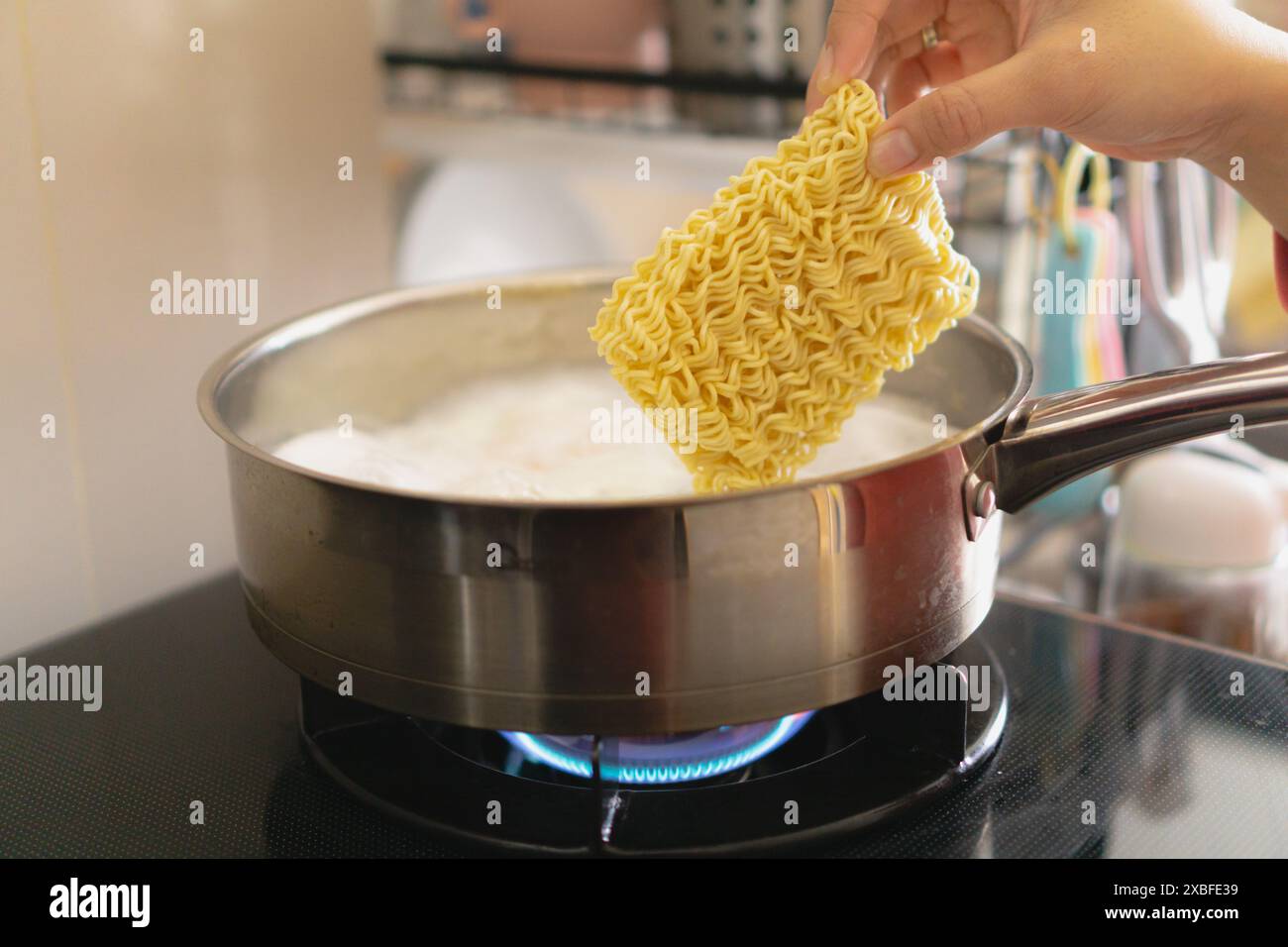 cooking instant noodle with an egg, in the stainless pan Stock Photo ...