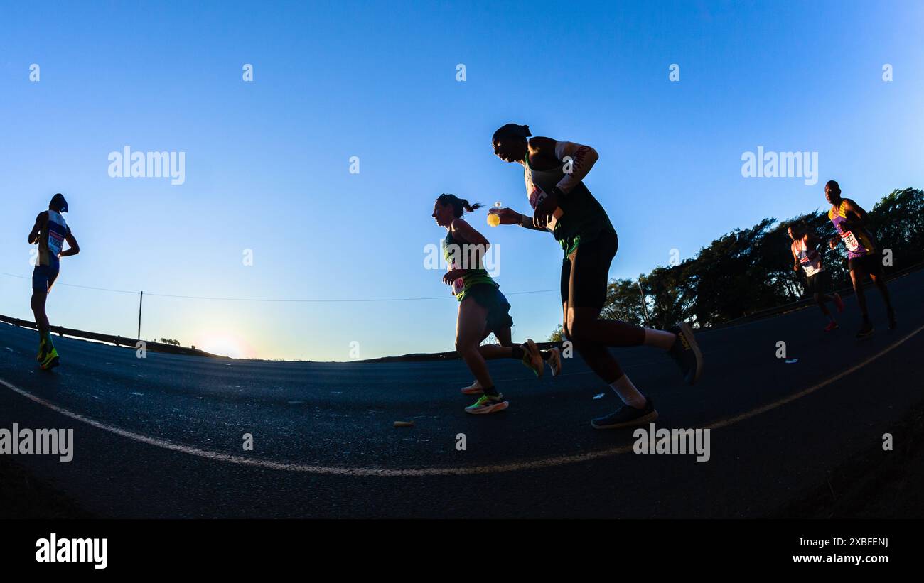 Marathon runners silhouetted morning dawn sunrise running up hill in ...