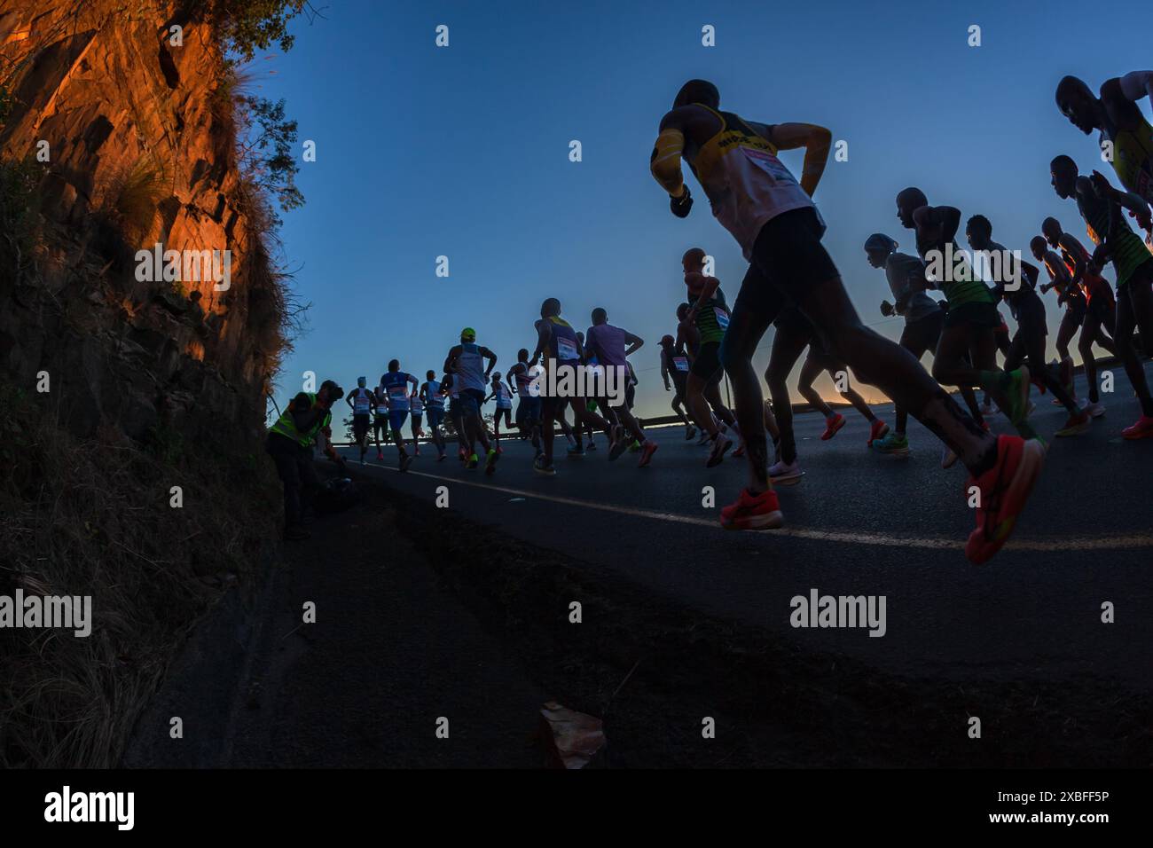 Marathon runners silhouetted morning dawn sunrise running up hill in ...