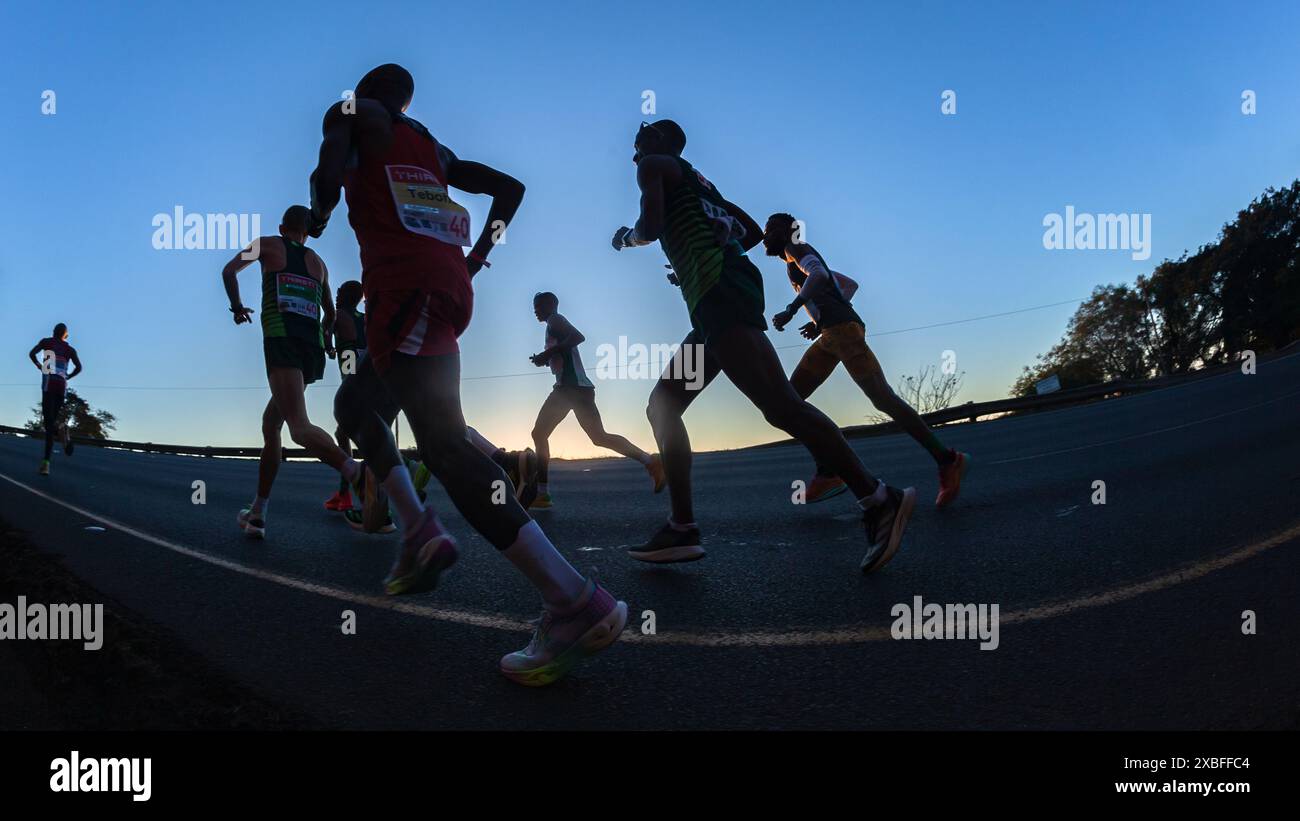 Marathon runners silhouetted morning dawn sunrise running up hill in ...