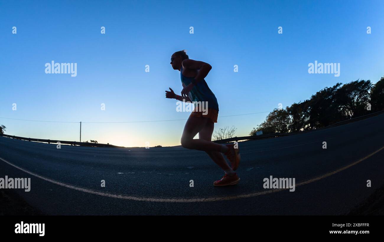 Marathon runners silhouetted morning dawn sunrise running up hill in ...