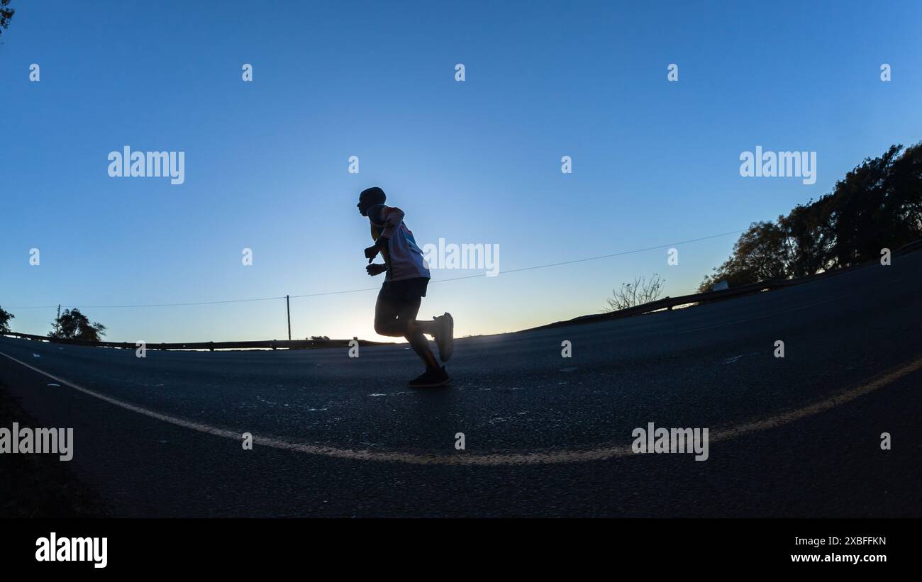 Marathon runners silhouetted morning dawn sunrise running up hill in ...