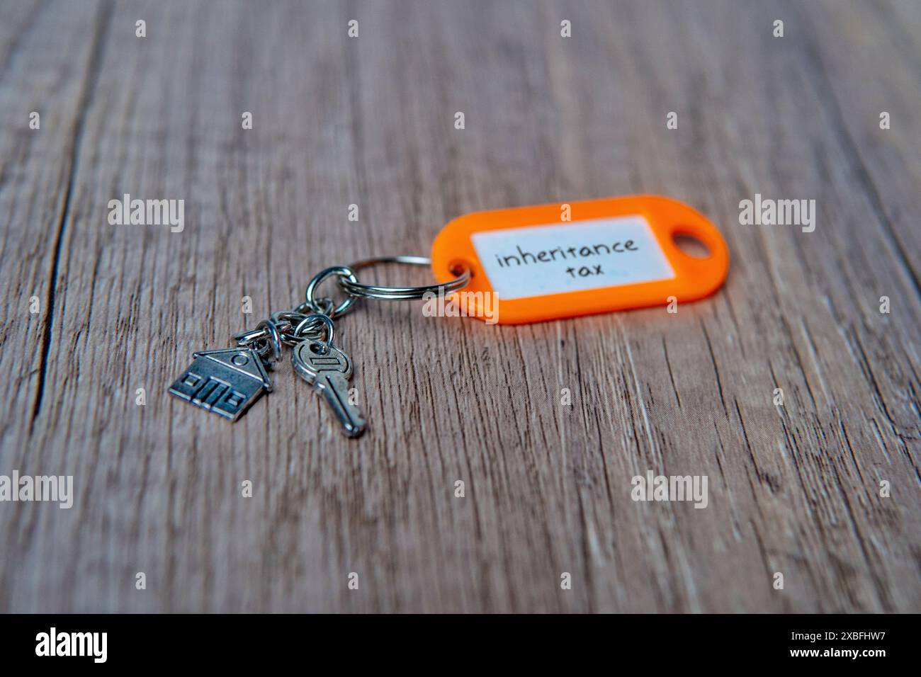 A close-up photo of a keys and a house-shaped keychain on wooden table ...
