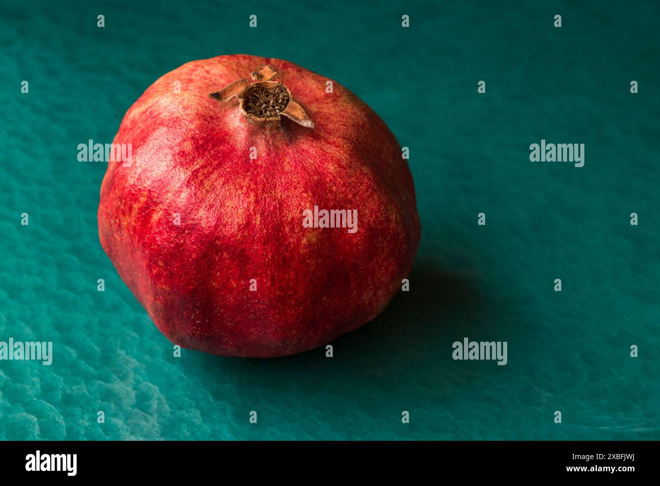 Red Big Pomegranate Fruit Close-Up On A Turquoise Background Stock ...