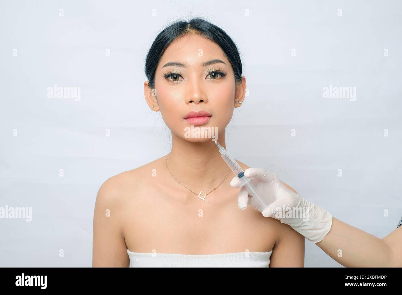 Asian Woman with Hair in a Bun Undergoing Botox Injection for Skin ...