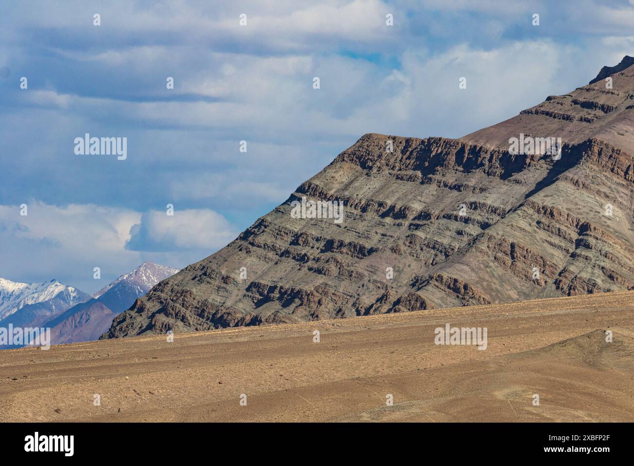 An abstract landscape of barren mountain ranges and snow clad mountains ...