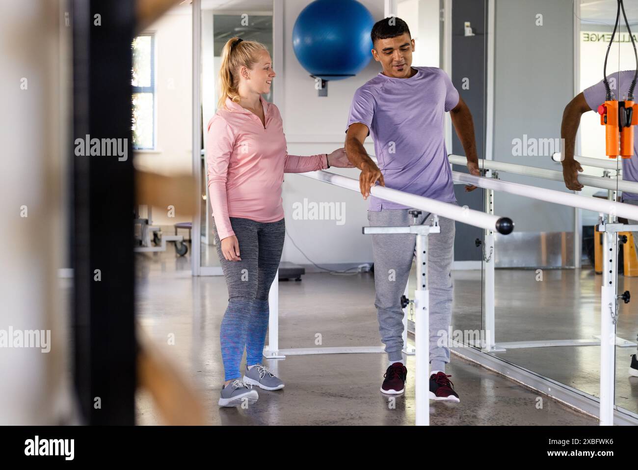 Biracial man and female physical therapist engaging in rehabilitation ...