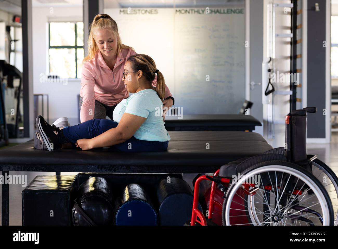 Quadriplegic biracial woman gets help from female therapist at a rehab ...