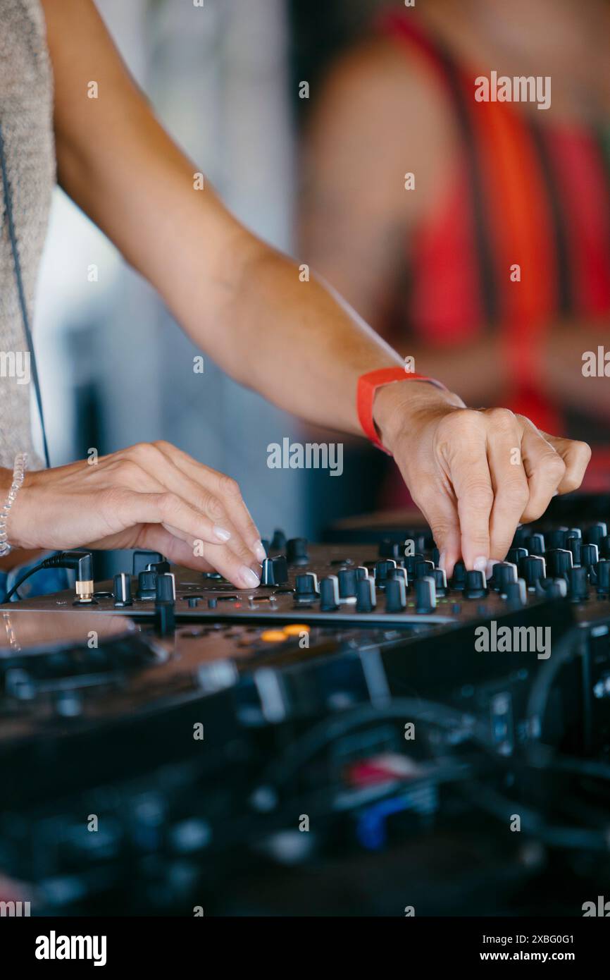 woman DJ Hands creating and regulating music on dj console mixer in a ...