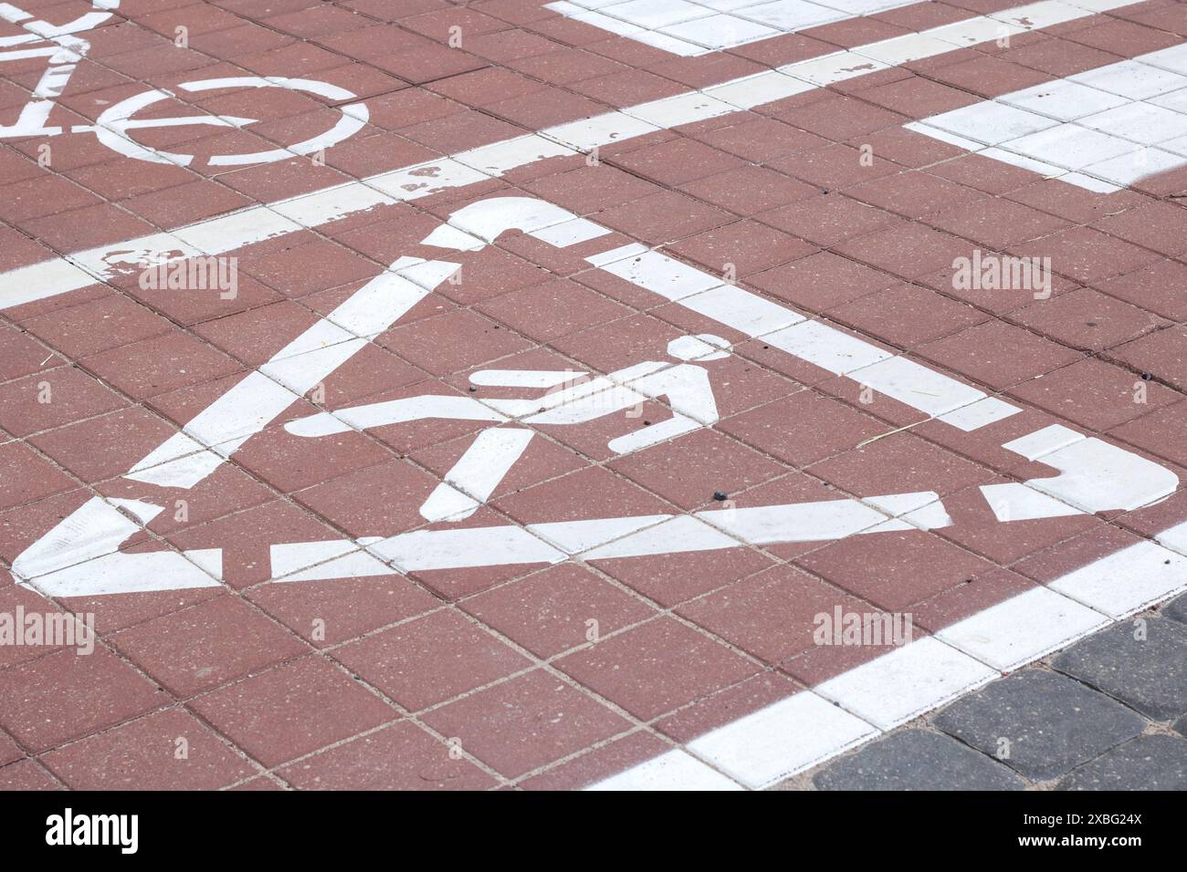 A pedestrian crossing sign is painted on the brick pavement, a common ...