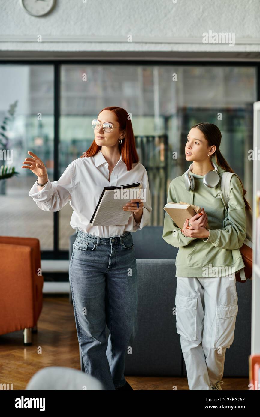 A redhead woman is teaching a teenage girl in an office setting ...