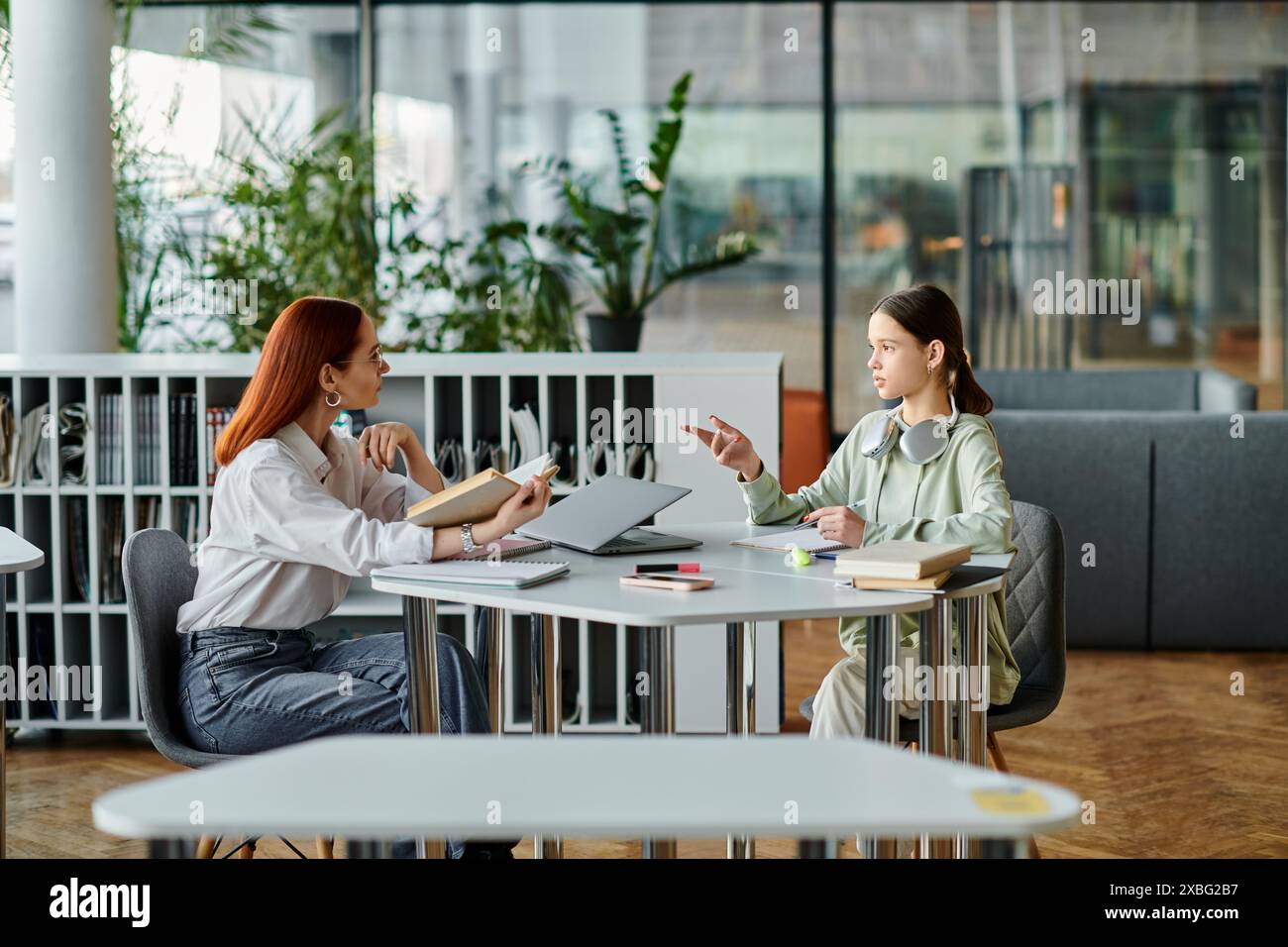 redhead woman is tutoring a teenage girl, engaging in a discussion ...