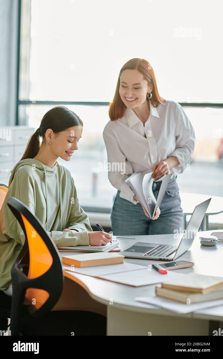 A redhead tutor guides a teenage girl through after-school lessons at a ...