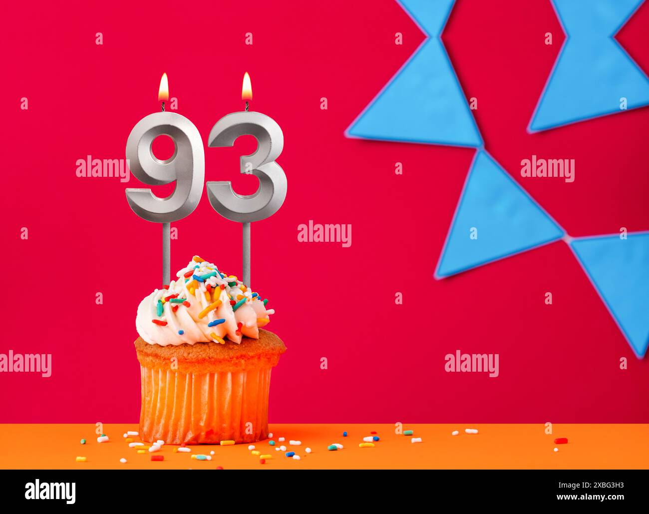 Number 93 candle with birthday cupcake on a red background with blue ...