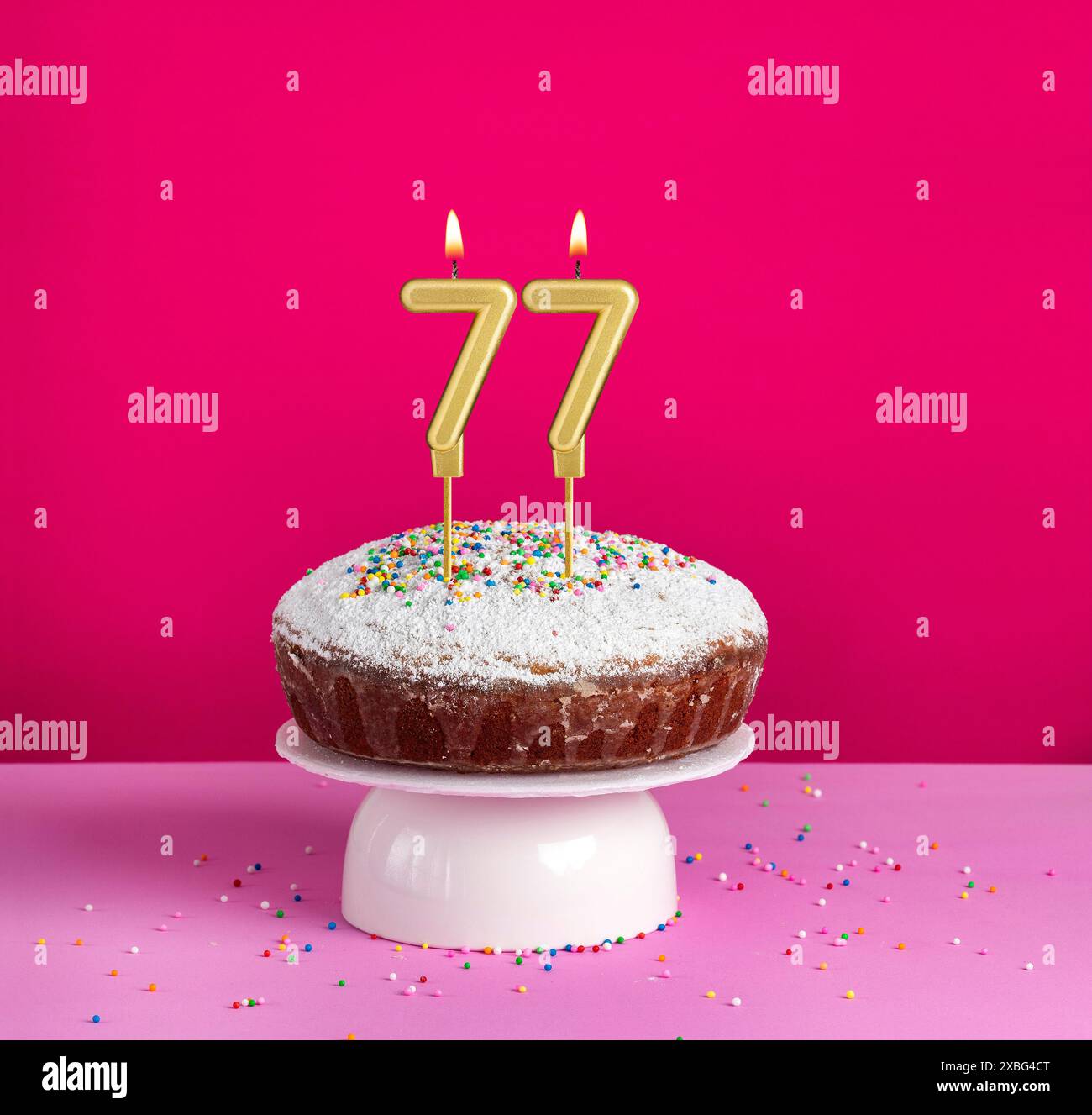 Birthday cake with number 77 candle on pink background Stock Photo - Alamy
