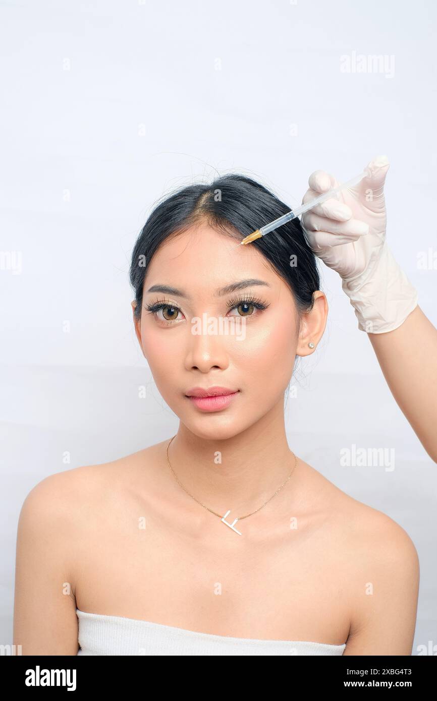 Asian Beauty with Hair in a Bun Receiving injection Botox Treatment to ...