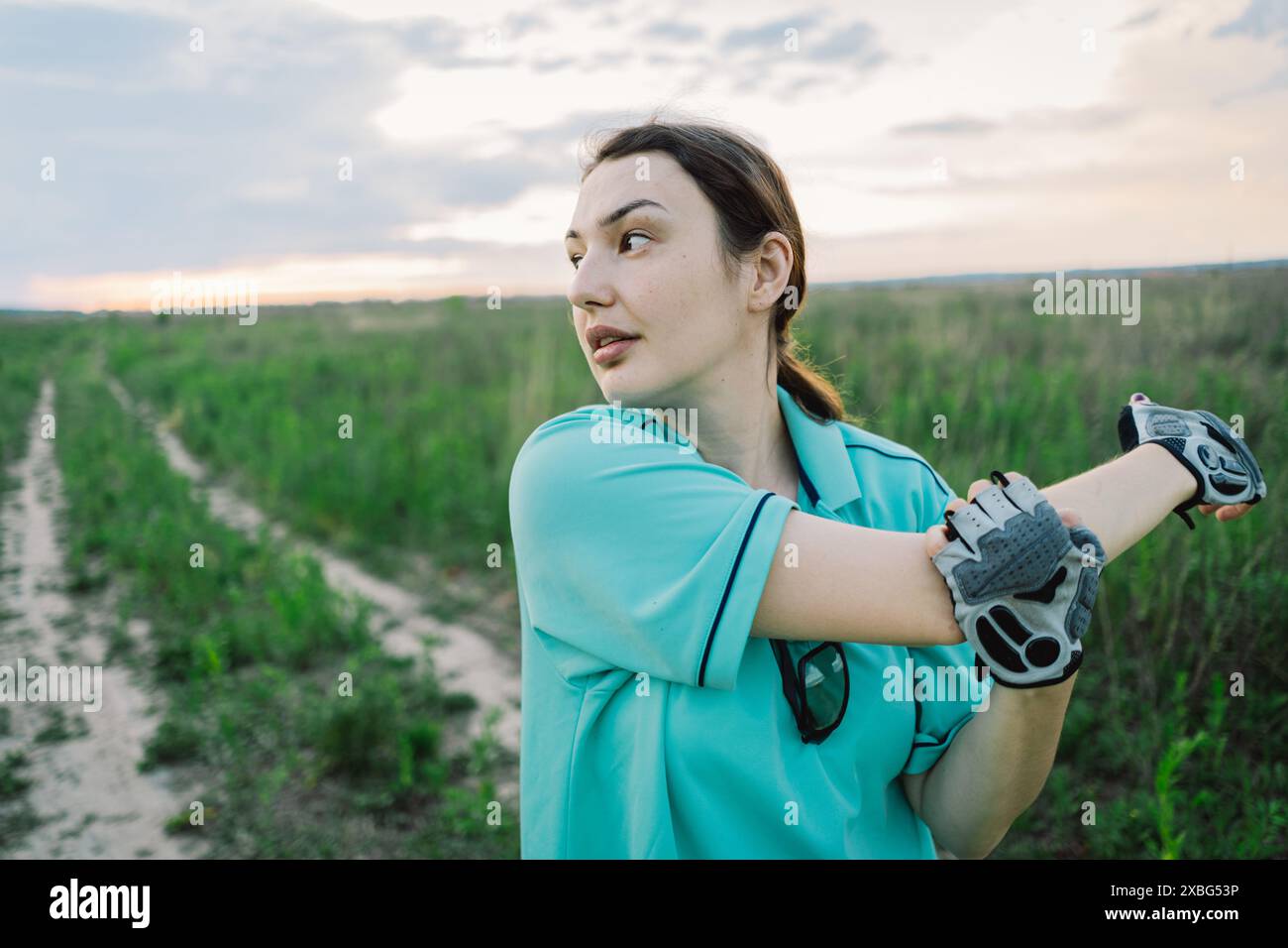 Woman Stretching Before Bike Ride in Green Field Stock Photo - Alamy