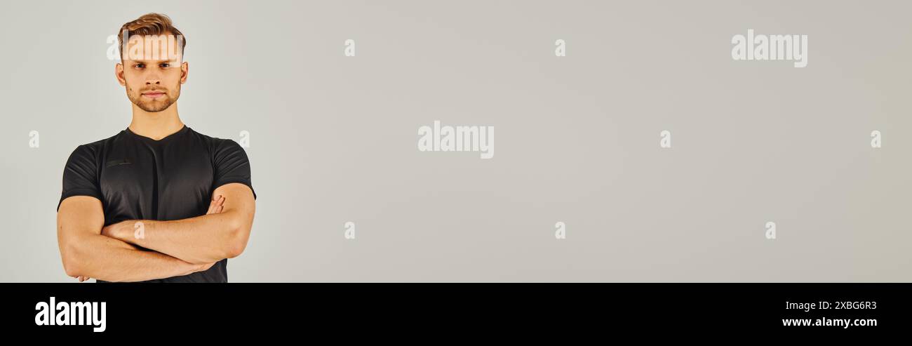 A muscular man showcases his strength with folded arms against a white ...