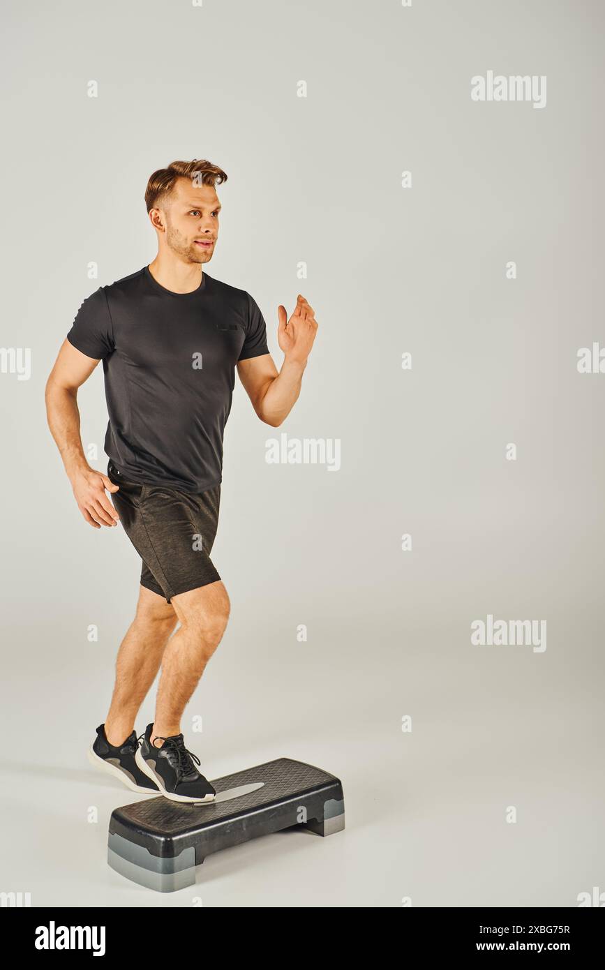 A young sportsman in active wear energetically running on a stepper in ...