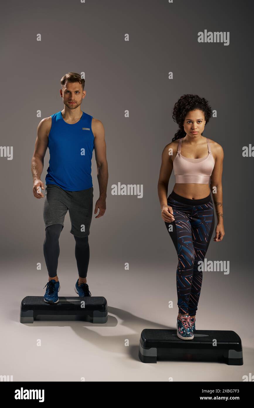 Multicultural, fit couple in active wear balancing on steppers in ...