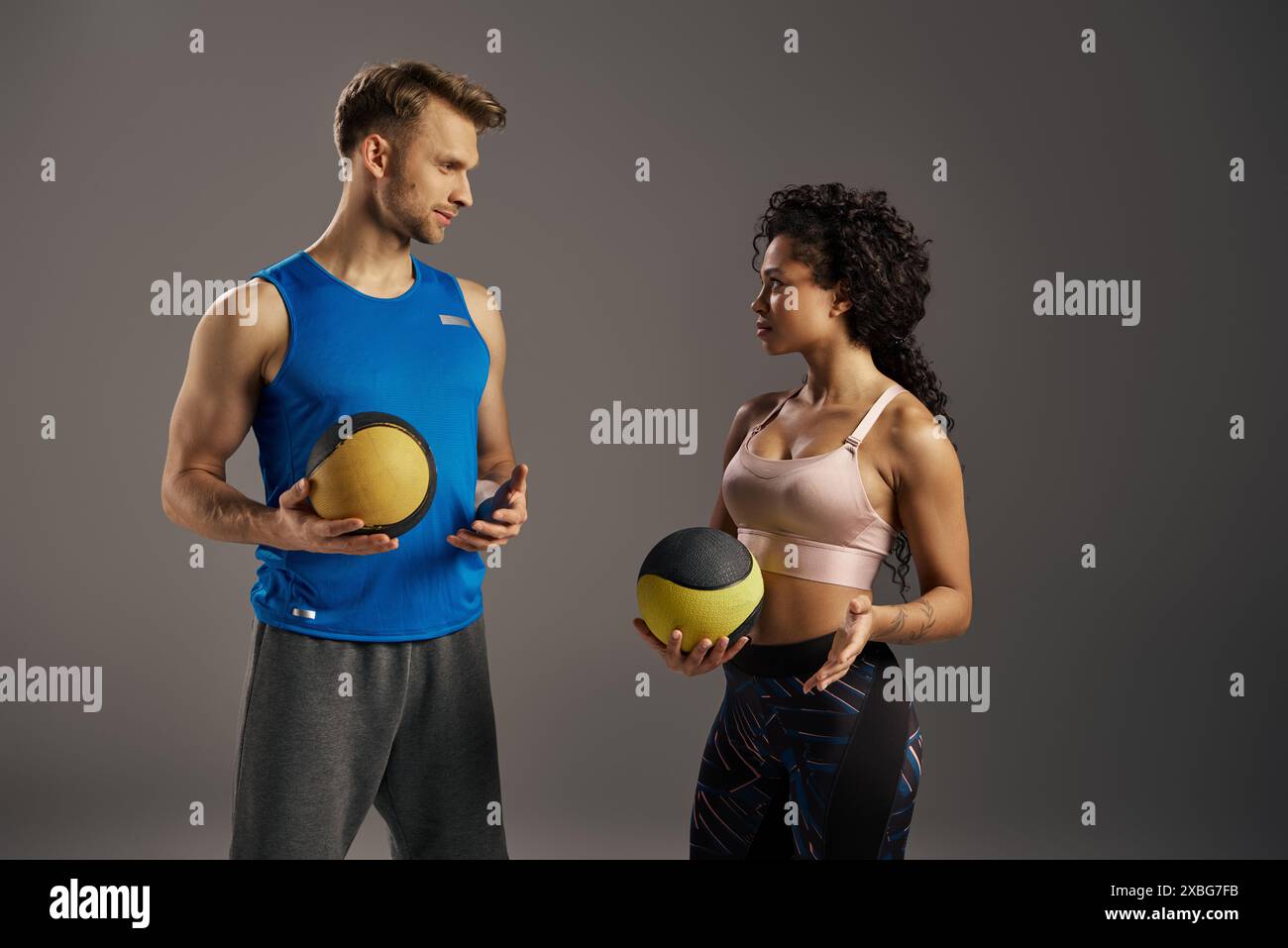Young multicultural and fit couple in active wear standing next to each ...