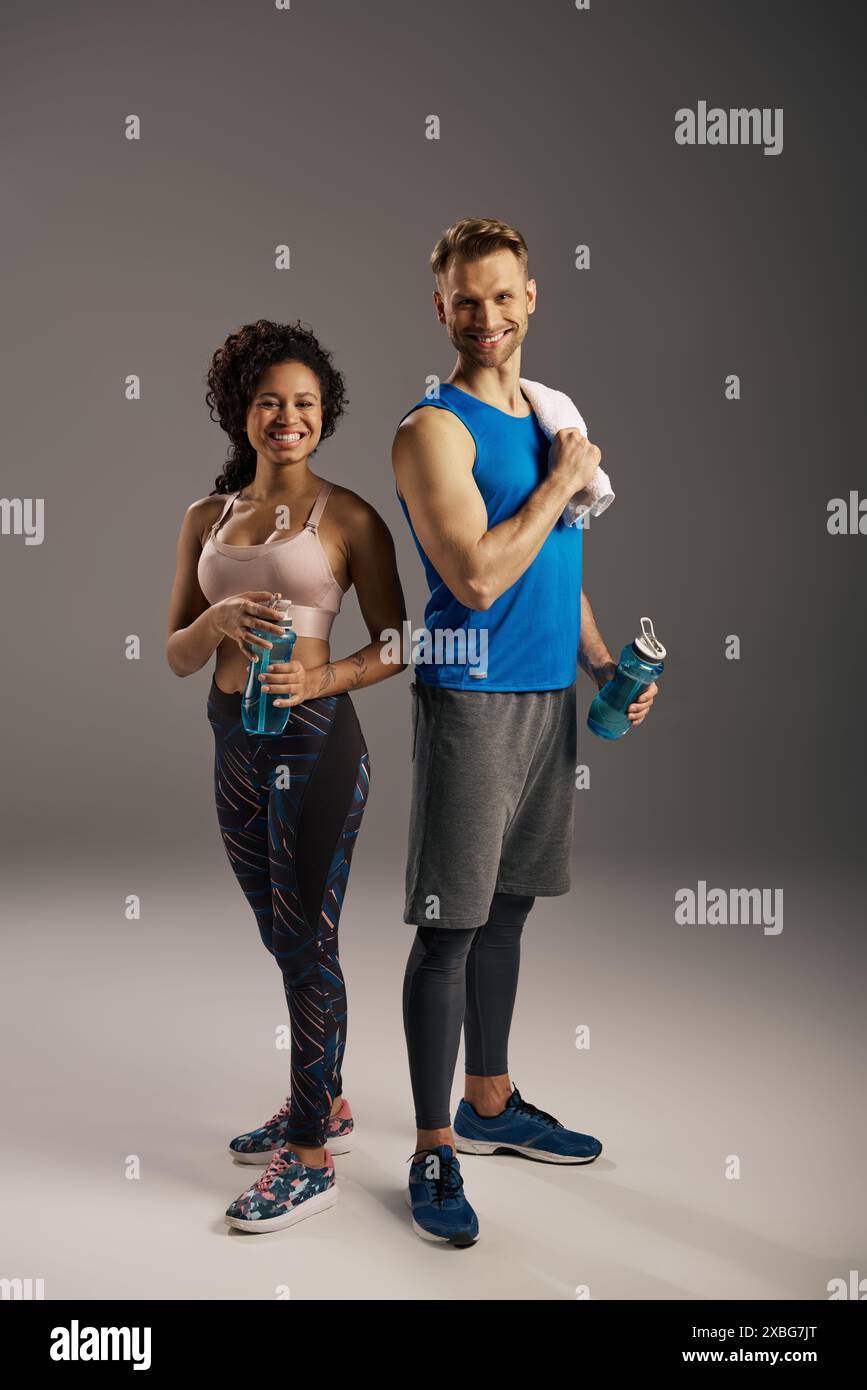A young, fit, multicultural couple in active wear posing confidently in ...