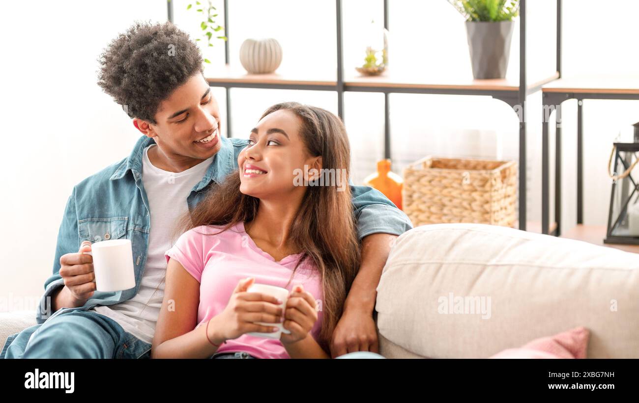Teen Lovers Relaxing on a Couch and Drinking Coffee Together Stock ...