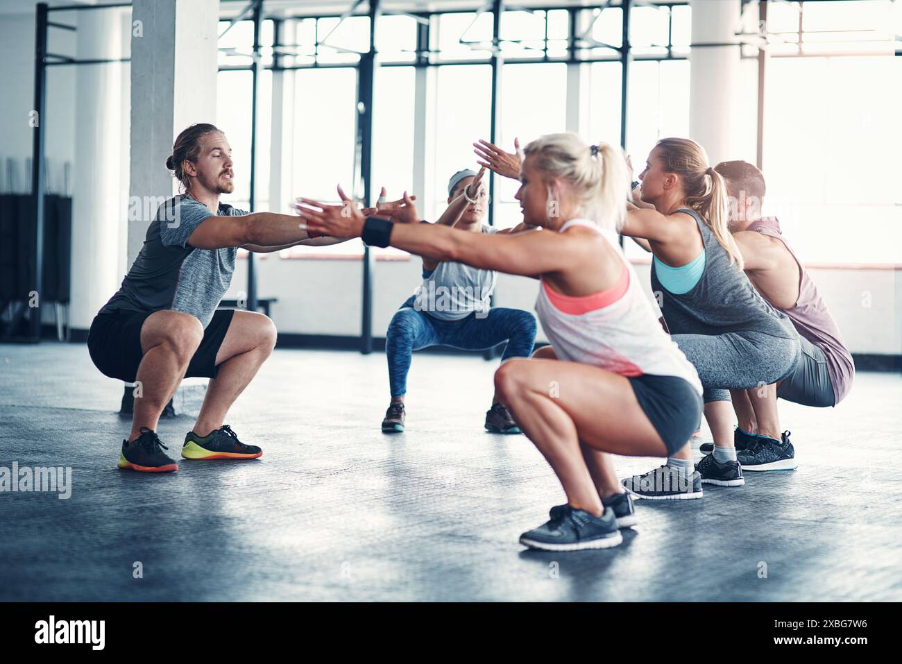 People, personal trainer and squating exercise for fitness in health ...