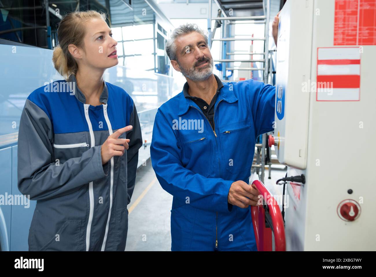 two workers doing maintenance on a machine Stock Photo - Alamy