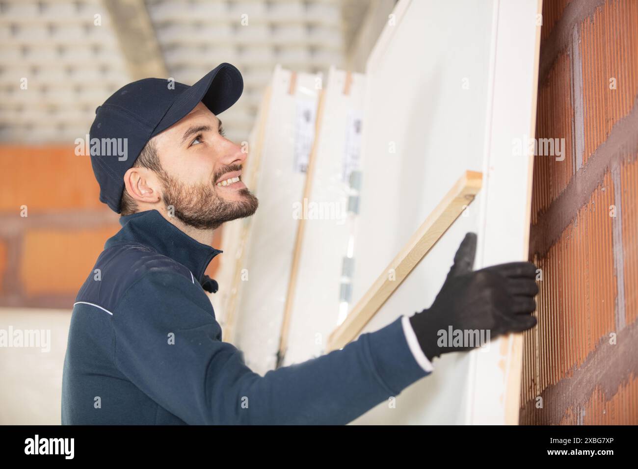 young manual worker lifting materials into place Stock Photo - Alamy