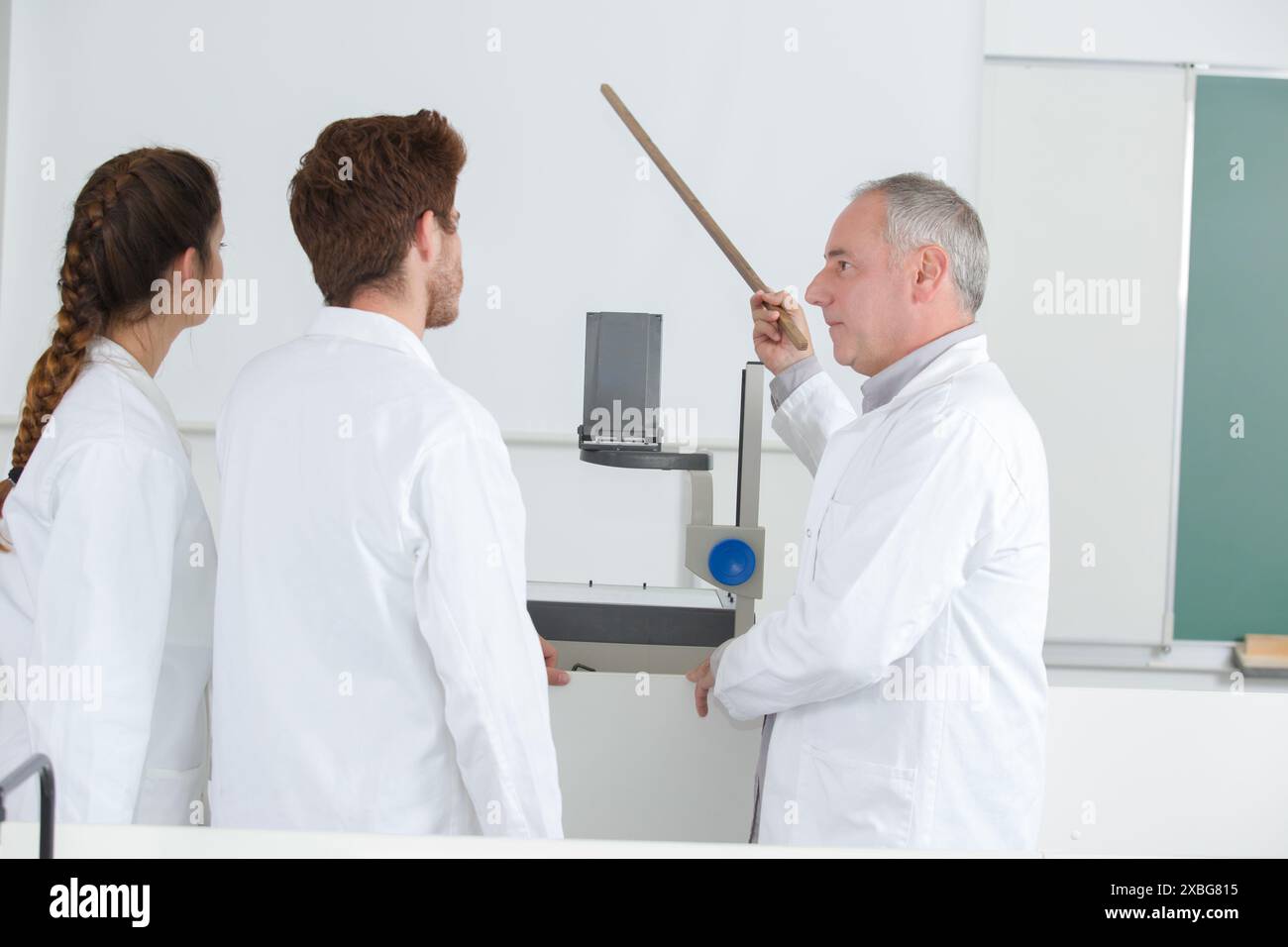 teacher showing projector screen to male and female students Stock ...