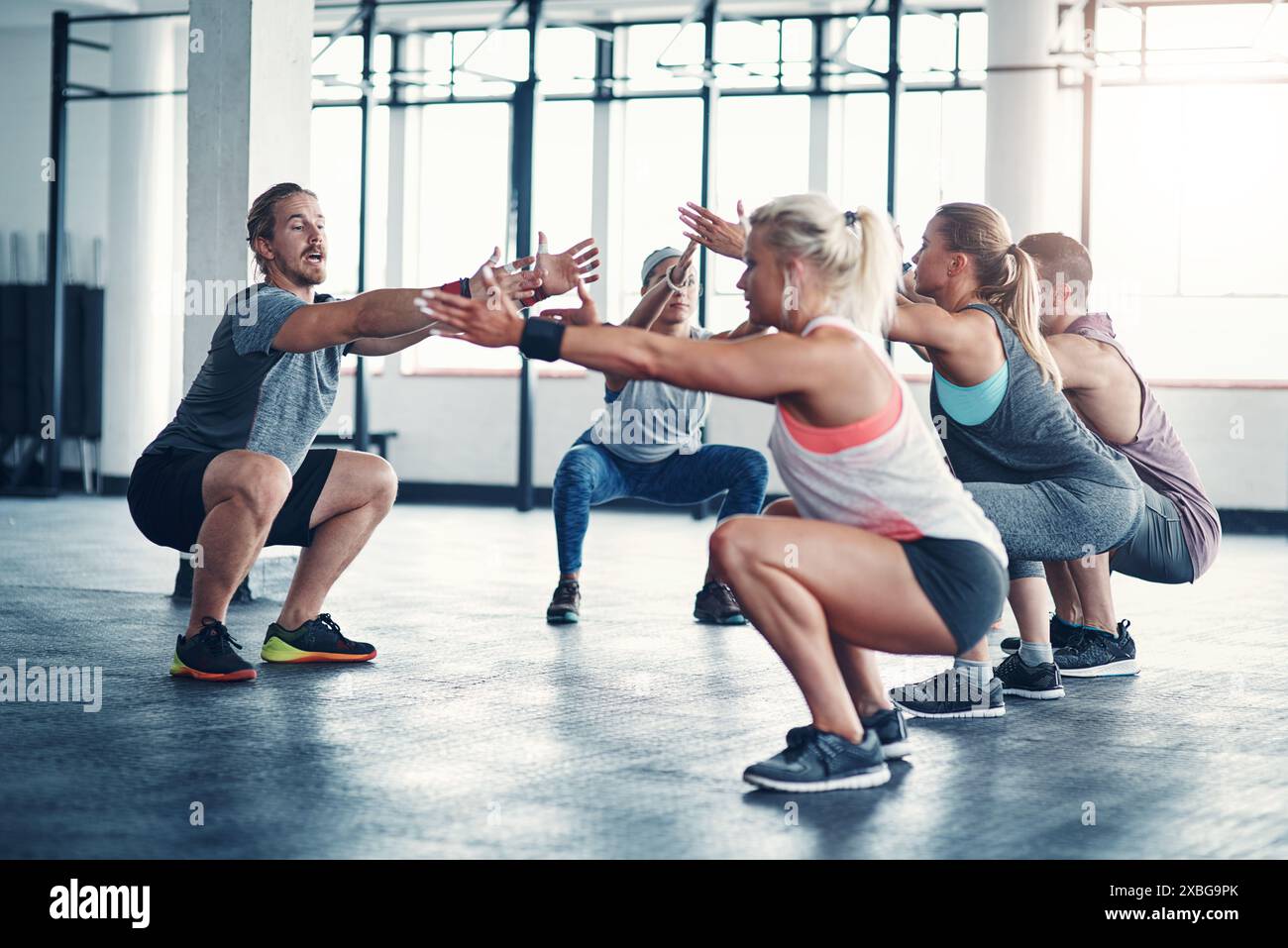 People, personal trainer and squat exercise for fitness in health club ...