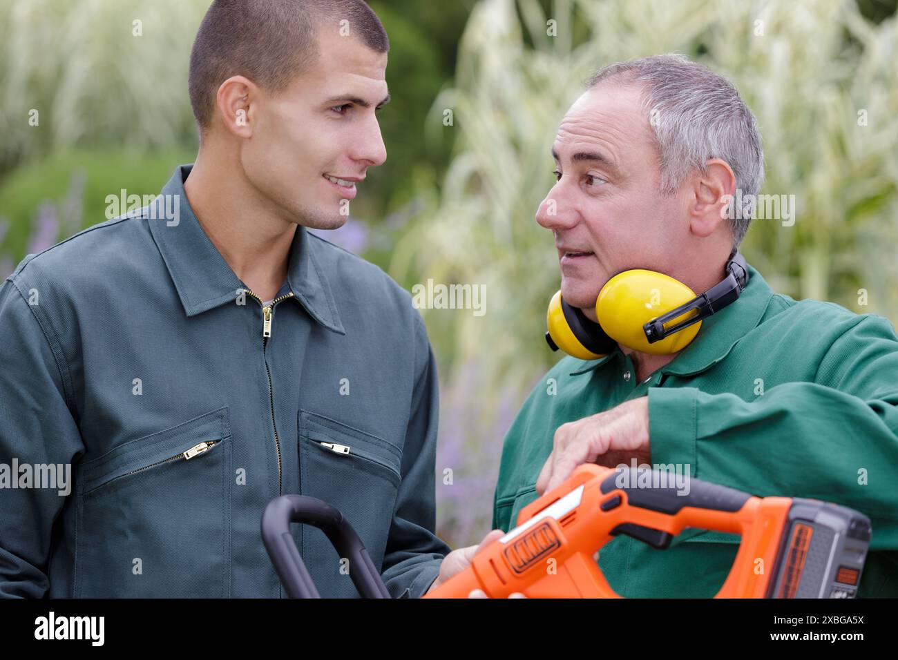 happy gardeners talking at plant nursery Stock Photo - Alamy