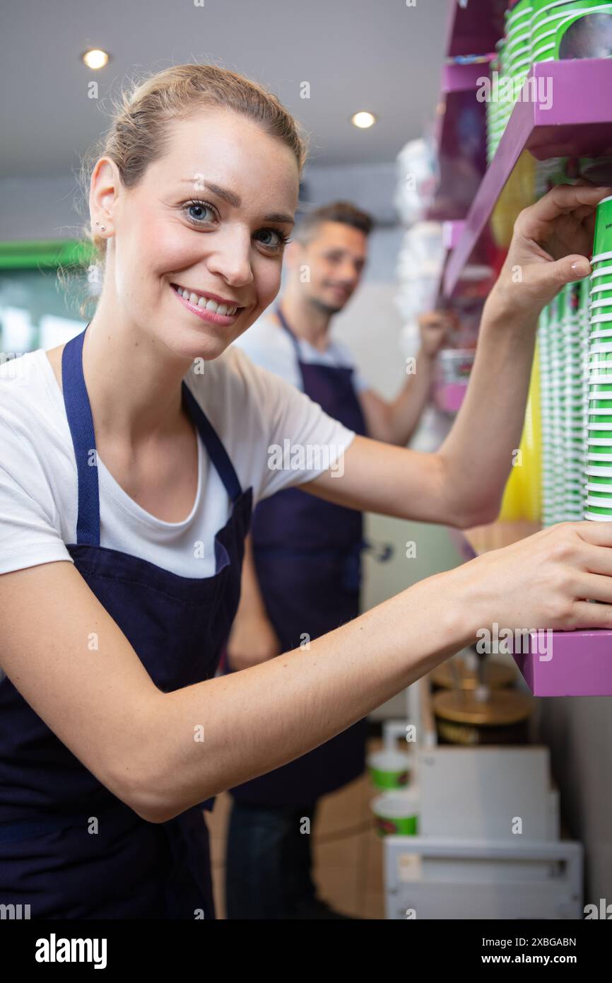 waitress in ice-cream parlour restocking cardboard pots Stock Photo - Alamy