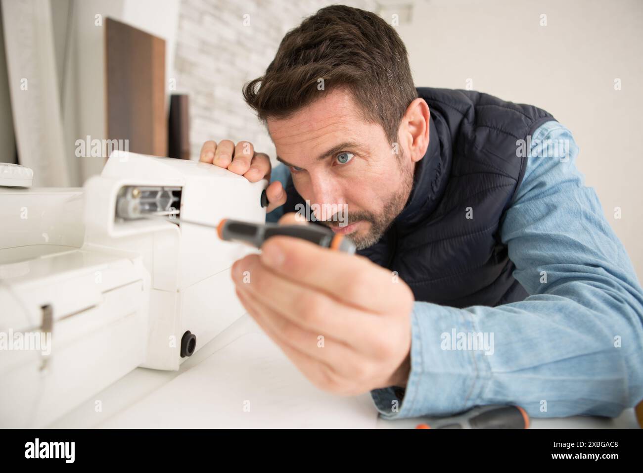 mechanic working in clothing factory repair sewing machine Stock Photo ...
