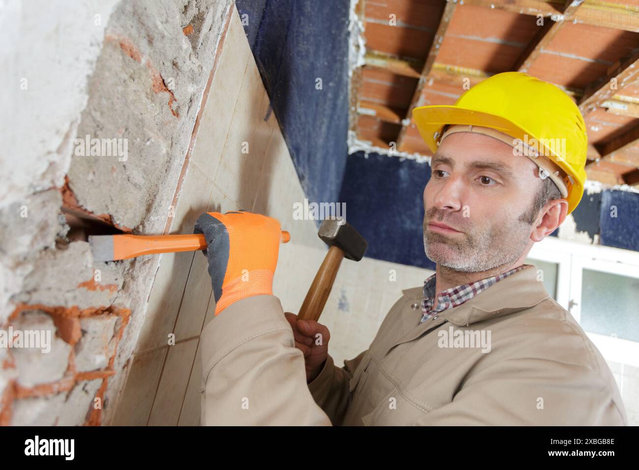 builders using a hammer to remove walls plaster Stock Photo - Alamy