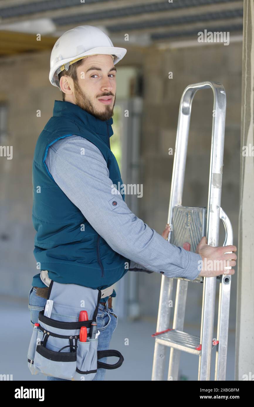 pensive handsome construction worker on ladder Stock Photo - Alamy