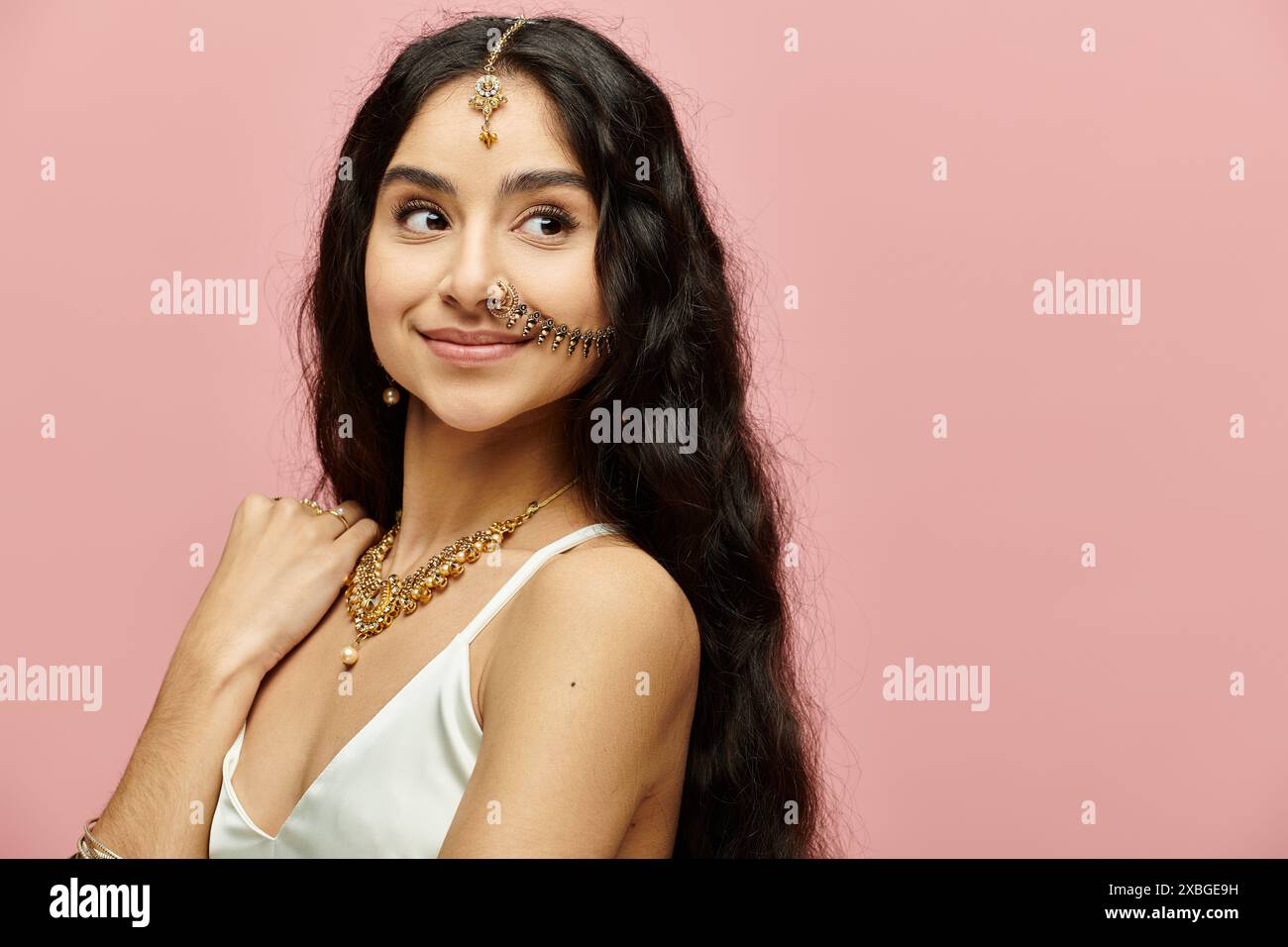 Young indian woman with long hair and jewelry striking a graceful pose ...